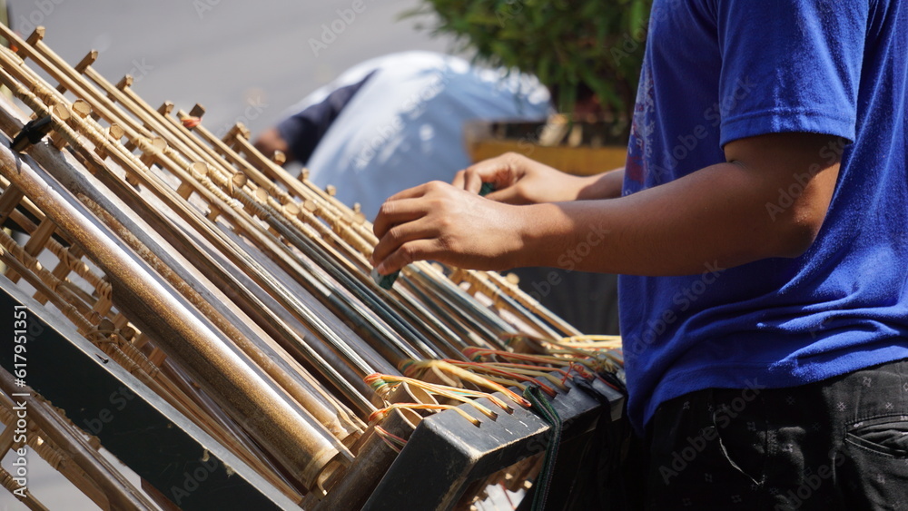 A man is playing angklung. That is a multitonal musical instrument that ...