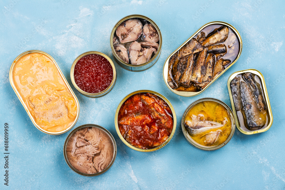 Variety of opened tins with different types of canned fish and seafood ...