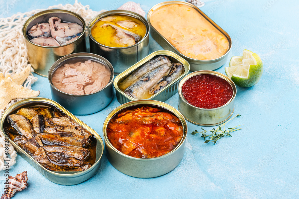 Variety of opened tins with different types of canned fish and seafood ...