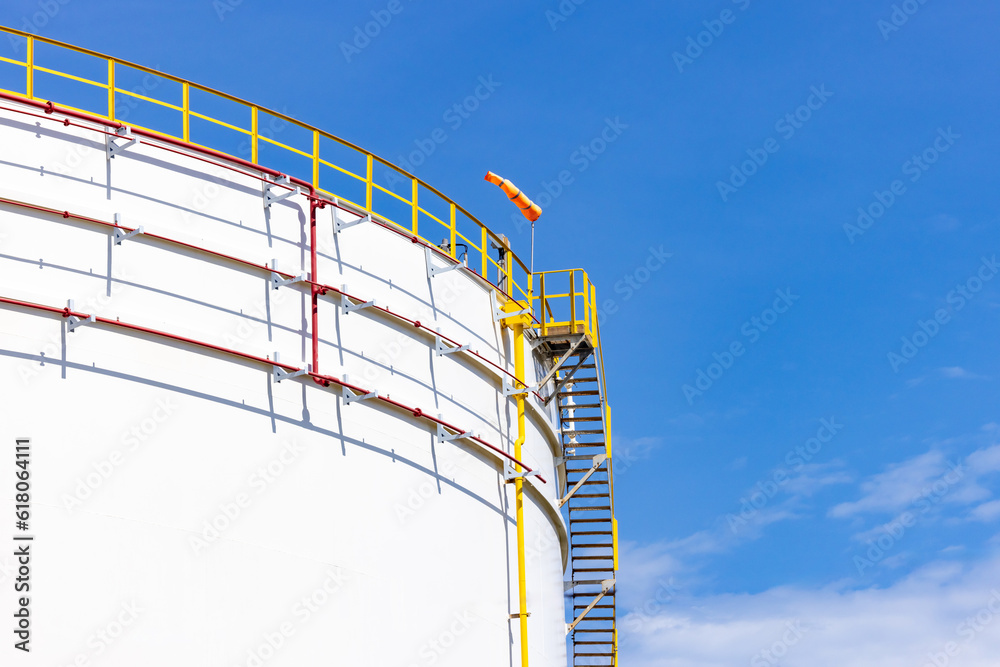 White oil storage fuel tanks at depot station with access ladder ...