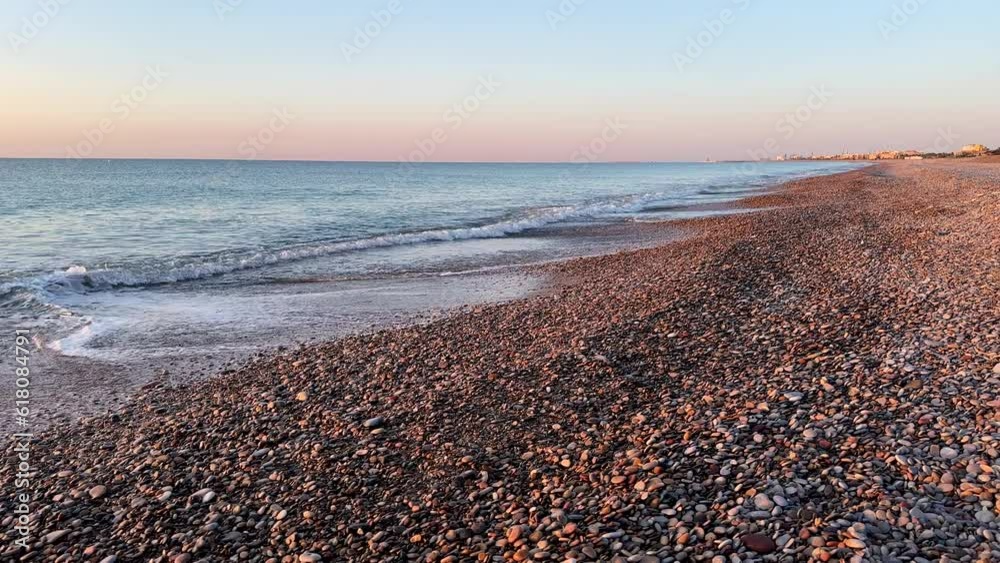Waves in sea on sunrise. Pebble stone beach on sunset. Sea beach shore ...