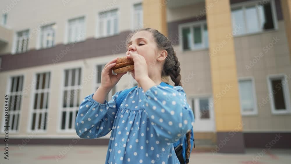 Girl having snack school.Schoolgirl takes food at recess.Happy ...