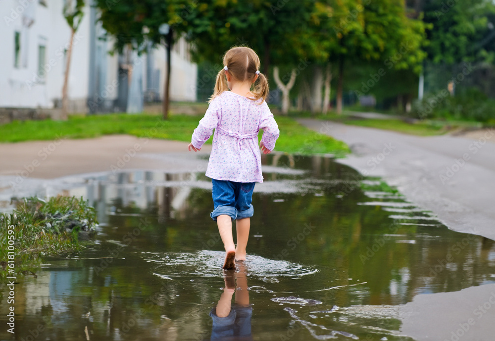 Girl to walk barefoot in a puddle splashing water in the rain Stock ...