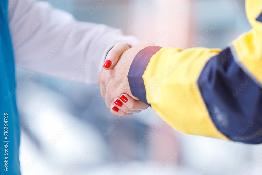 Close-up photo of a young artist shaking hands with female customers ...
