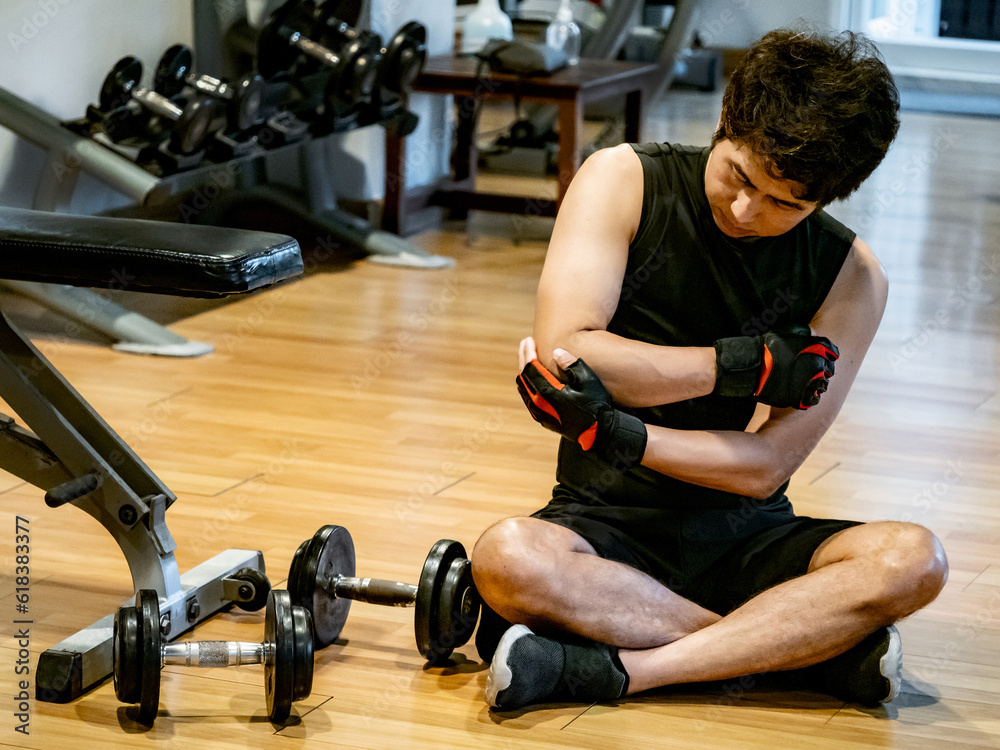 Asian sport man feeling strong elbow pain after doing weight training ...