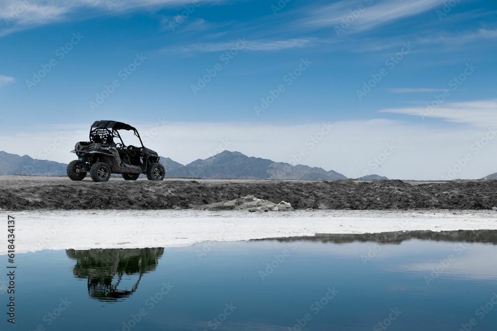Utility Task Vehicle (UTV) cruising along the water near the majestic ...