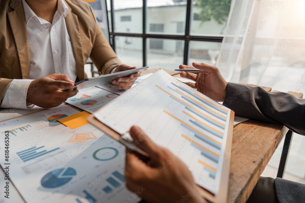 Teamwork process, Business team using a tablet to calculate the numbers ...