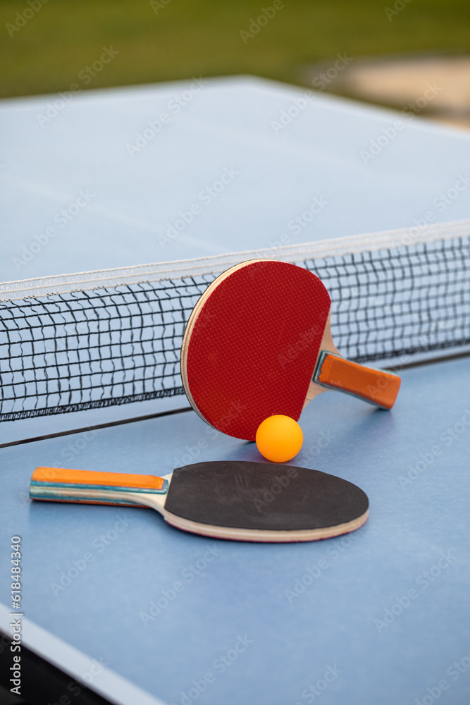 Table tennis. Blue ping pong table. Ping pong rackets and ball. The ...