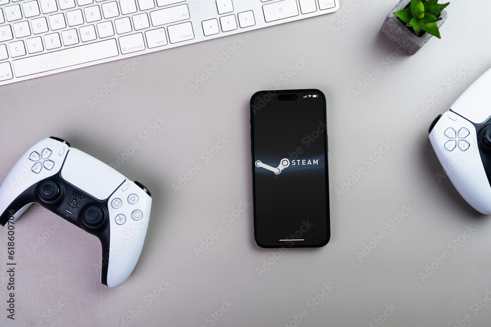 Steam app on the smartphone iPhone 14 Pro screen on gray table with PS5 ...