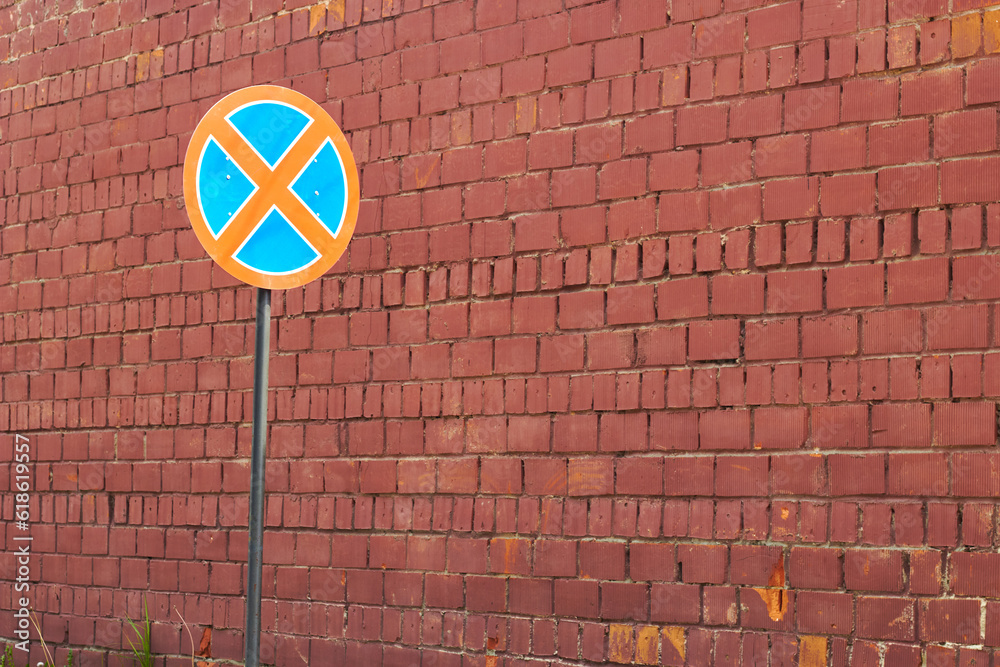 red brick wall and road round crossed out sign. Stock Photo | Adobe Stock