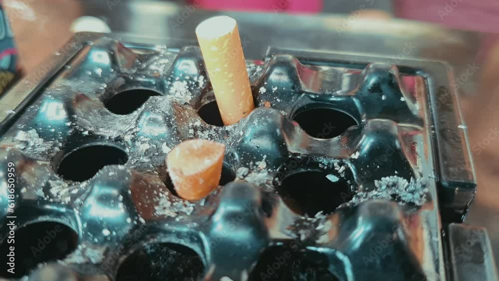 Man's Hand Extinguishing Cigarette In Ashtray, turning off cigarettes ...