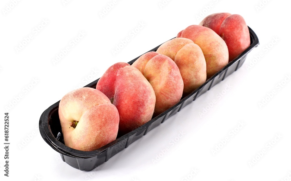 Flat peaches, known also as doughnut peaches, in a row on a narrow ...