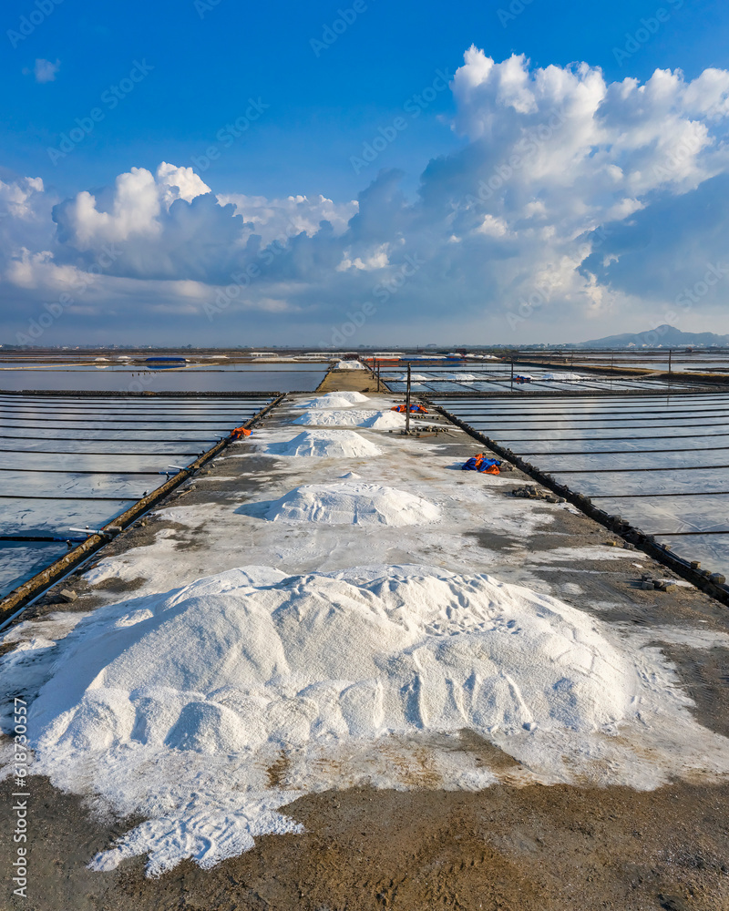 Field and Sea salt pile pyramid ready for harvest in salt farm. Sea ...