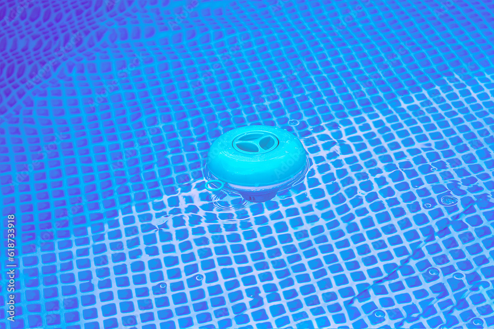 natural light. frame pool. a container with solid tablets floats in the ...