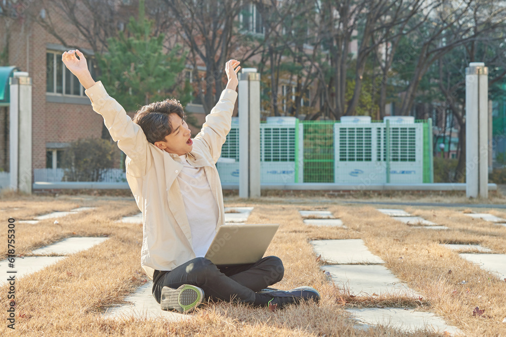 Young and attractive college student male model sitting on lawn at ...