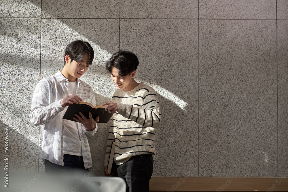Young male college student models leaning against the wall of a ...