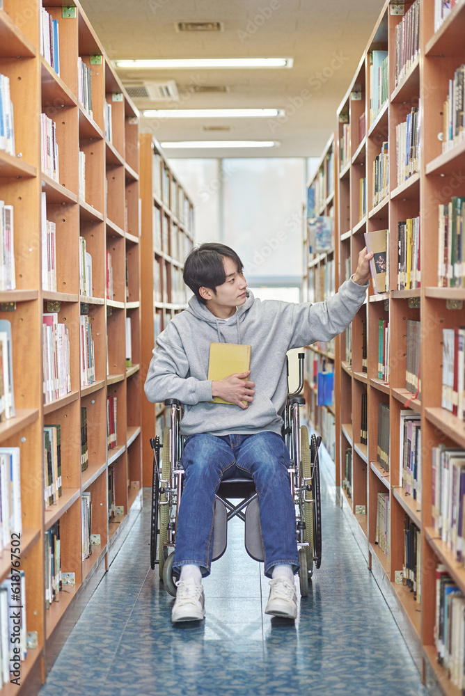 Asia South Korea university library bookcase in a wheelchair looking ...