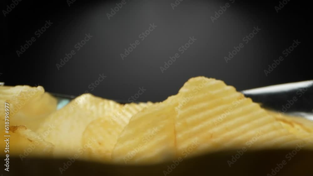 Macro video captures the fascinating process of picking up potato chips ...