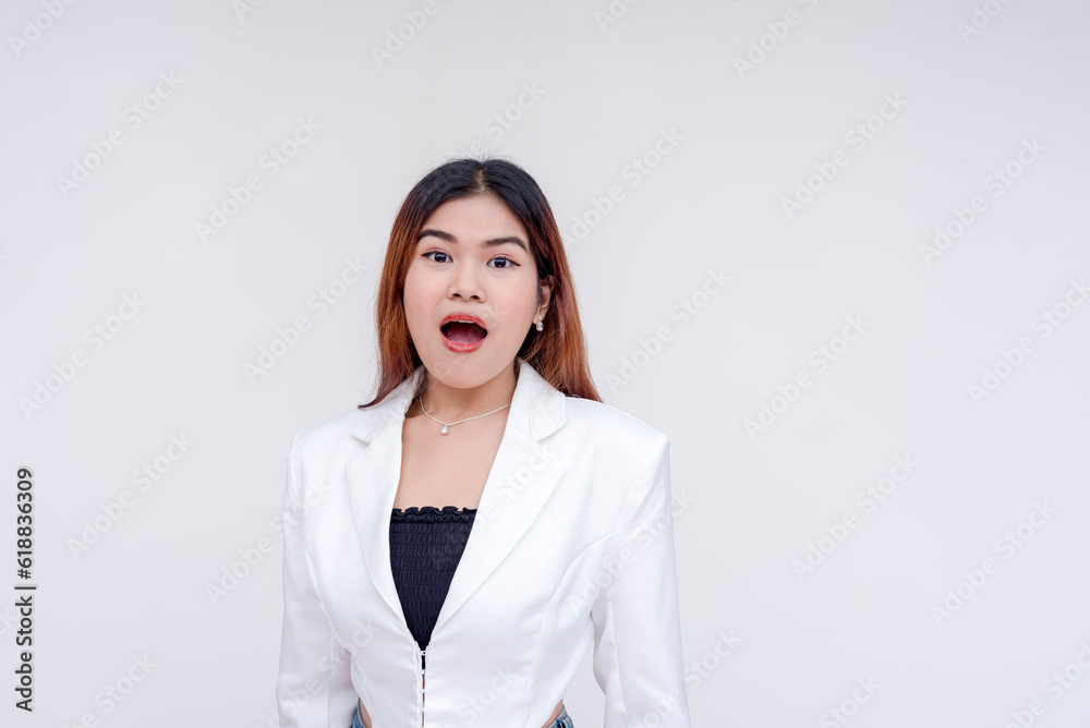 A surprised young woman with raised eyebrows and mouth wide open in ...