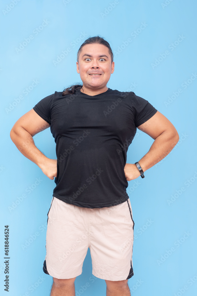 A strong and athletic male with fist on hips doing a superman pose to ...