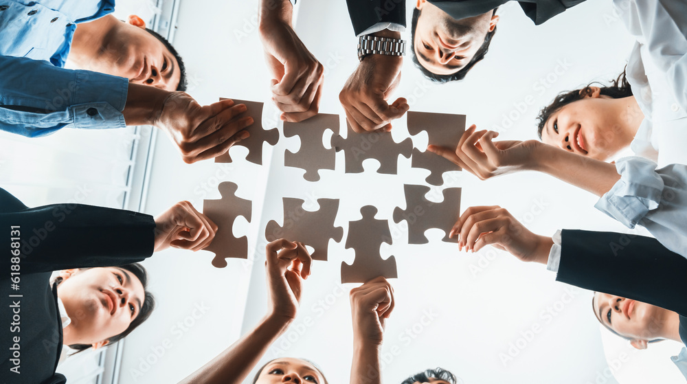 Multiethnic business people holding jigsaw pieces and merge them ...