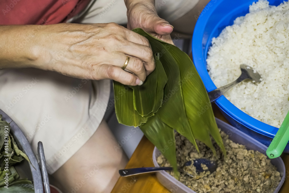 Photo of process for someone making Zongzi or traditional sticky rice ...