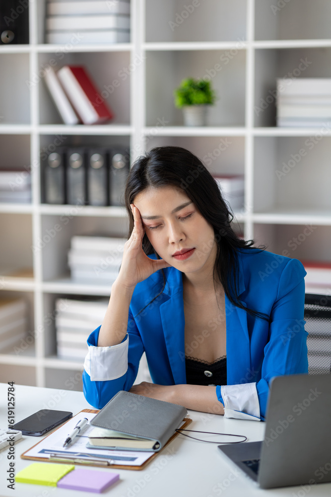 Beautiful asian woman suffering from stress due to working long hours ...