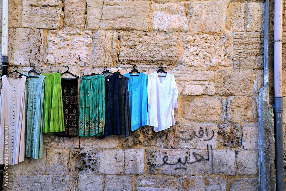 Clothes hanging in Jerusalem marketplace, incidental graffiti on wall ...