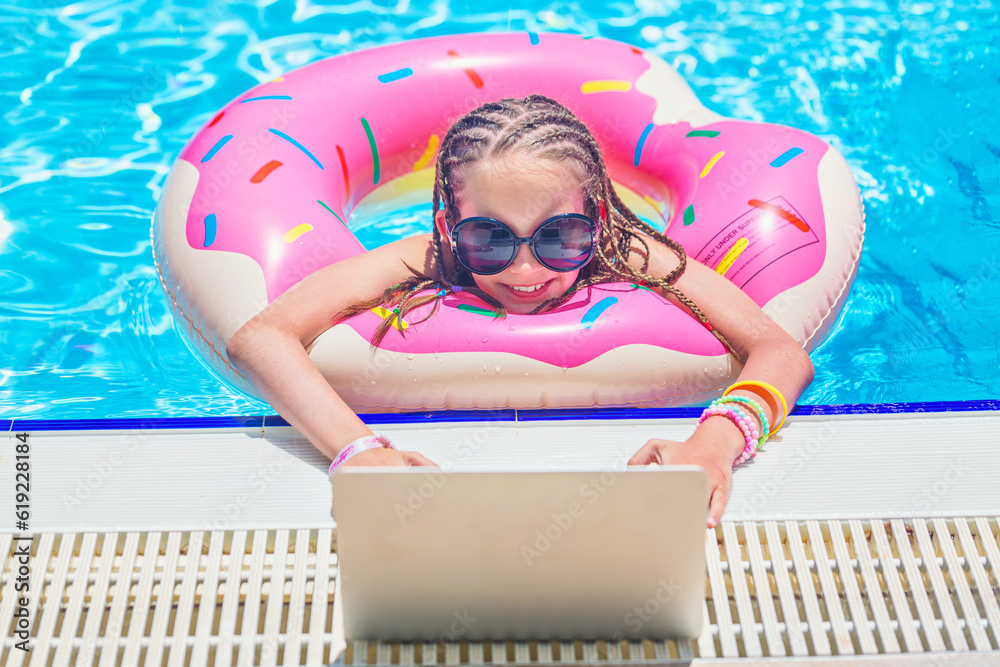 Young girl with sunglasses in inflatable circle in swimming pool using ...