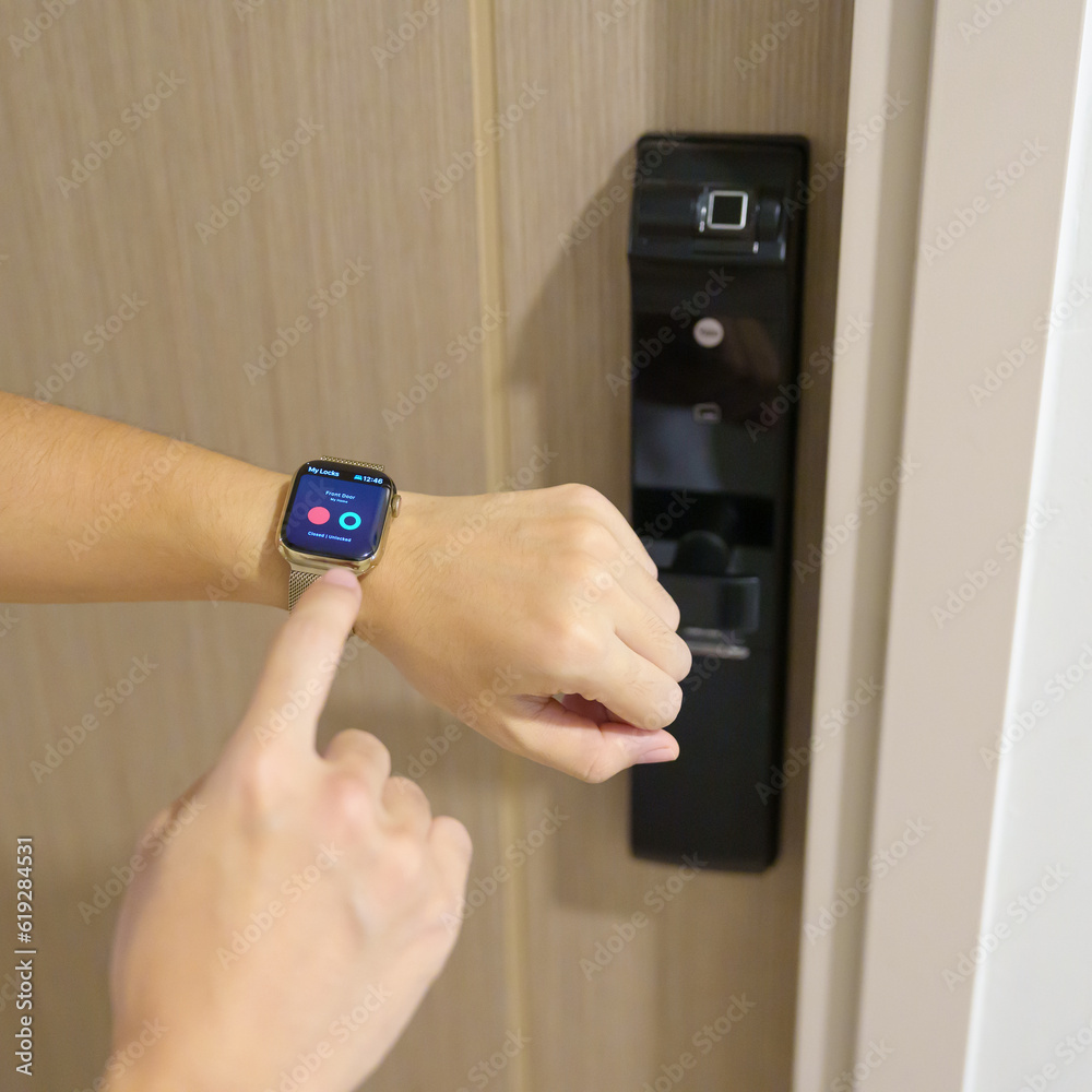 Hand using smartwatch for open digital door lock at home or apartment ...