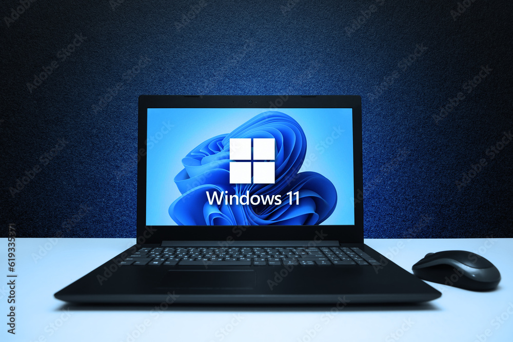 Windows 11 logo on the screen laptop computer with mouse on black ...