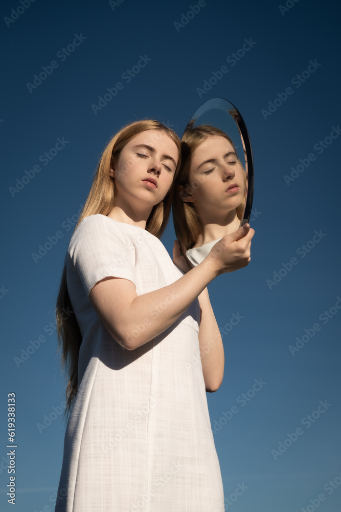art portrait of blonde girl in white dress holding round mirror showing ...