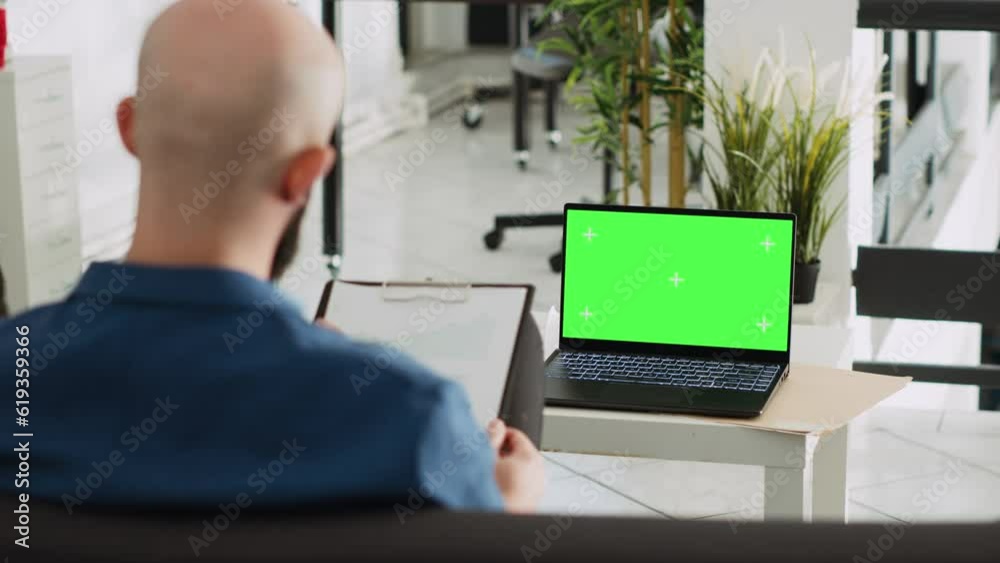 Company worker with greenscreen display reviewing documents, looking at ...