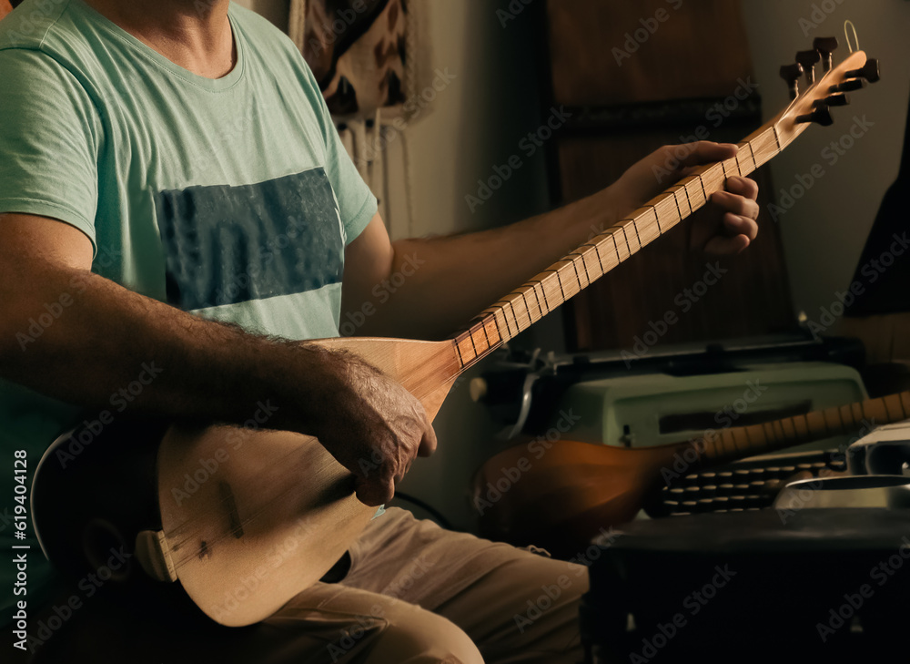 Man playing Turkish musical instrument baglama in local clothes ...