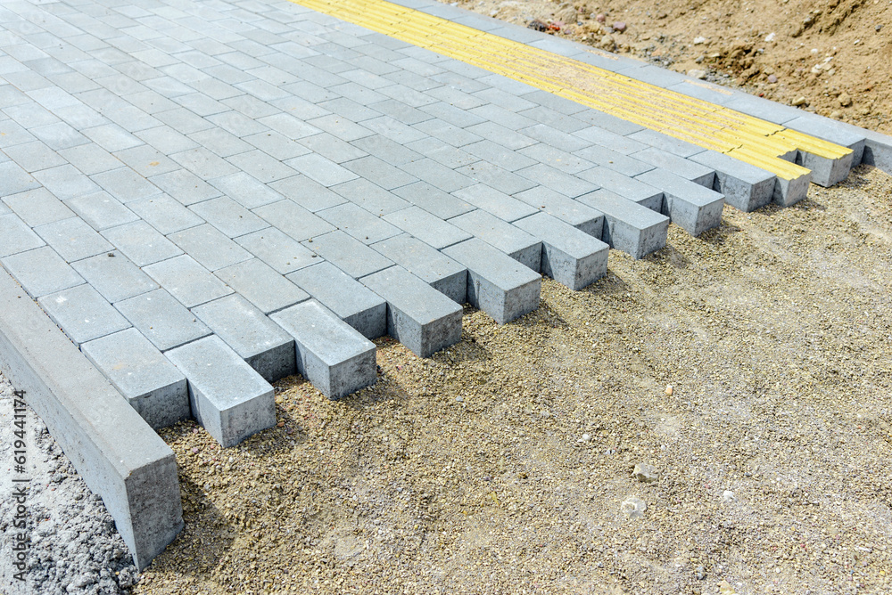 Pavement repairs and paving slabs laying on the prepared surface, with ...