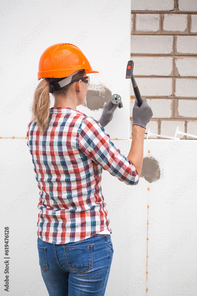 Insulation of the house with polyfoam. The worker is checking with the ...