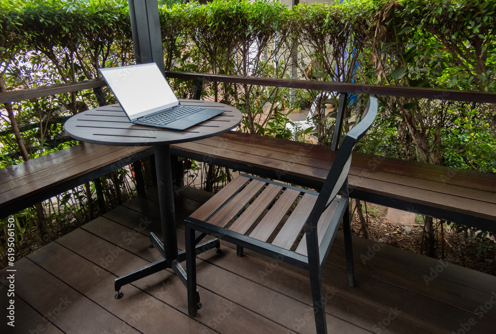 Foto de laptop sits on the wooden table on the balcony, creating a ...