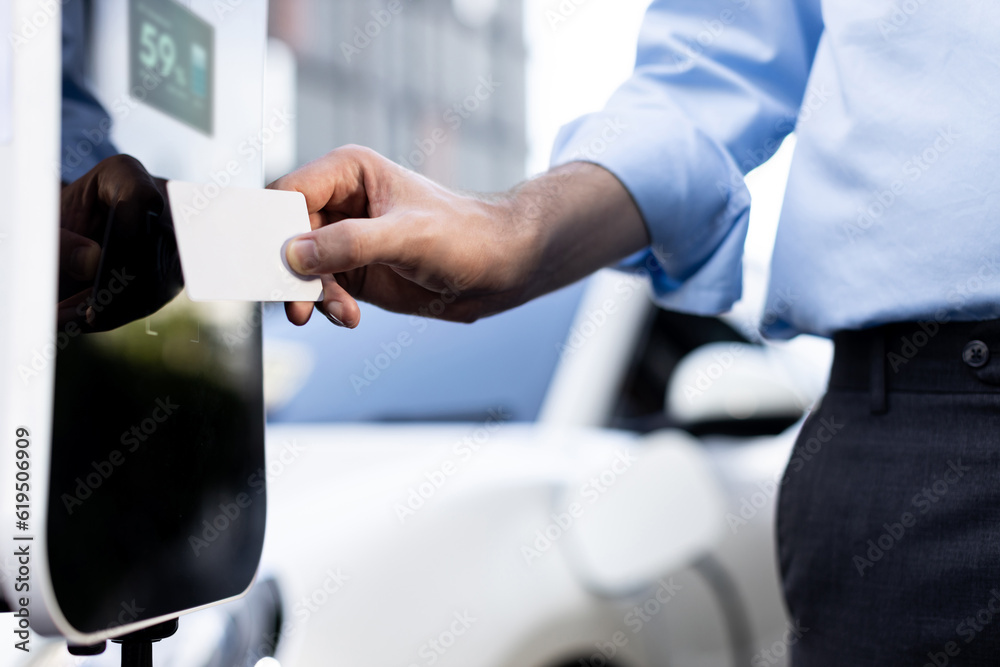 Hand holding credit card to pay public charging station and recharge ...