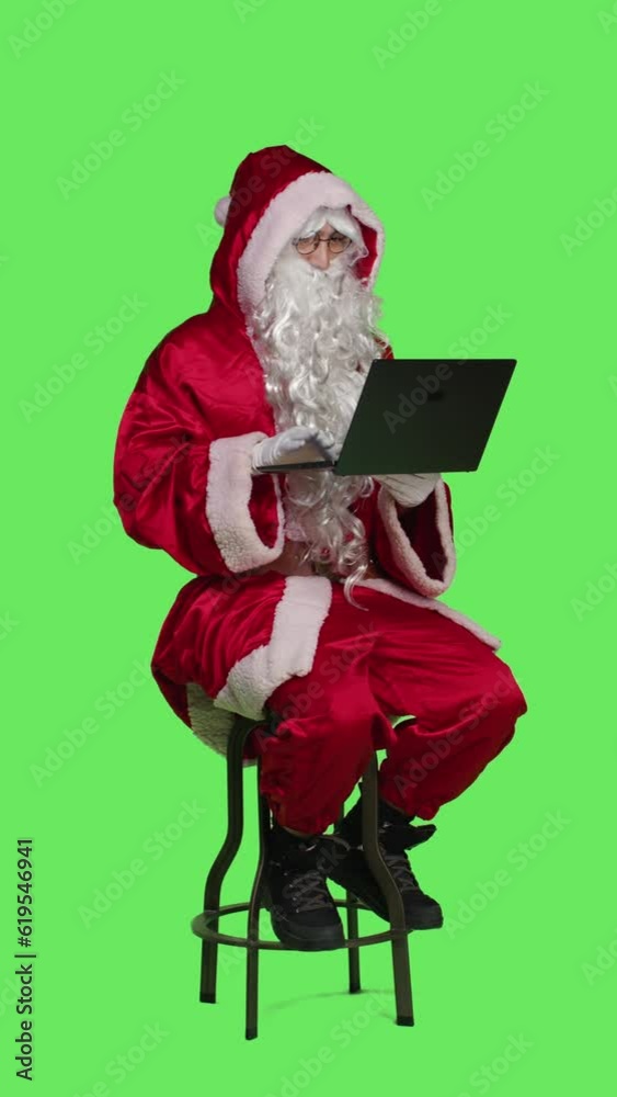 Vertical video Side view of modern santa character on laptop in full ... Vertical video Side view of modern santa character on laptop in full ...