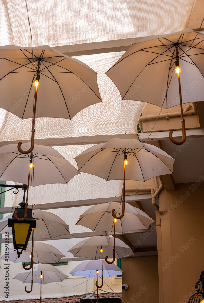 Street lighting with umbrellas in one of the narrow streets of ...