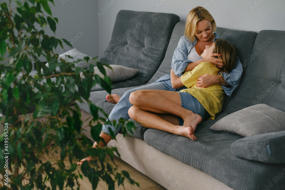 Young loving mother hugging her teenage daughter, mom demonstrating unconditional love for child ...