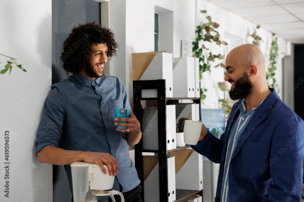 Businessmen enjoying coffee break together and laughing while relaxing ...