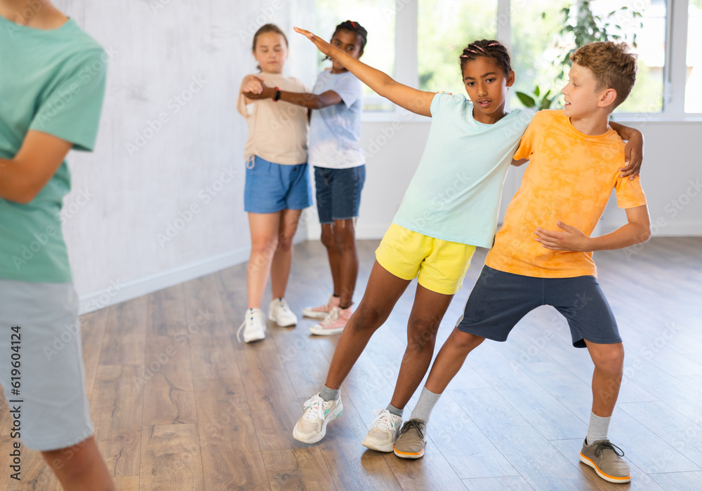 Positive tweenagers, boy and girl dancing together slow ballroom dances ...