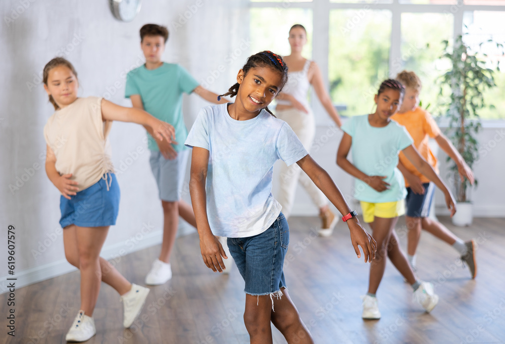 Active preteen boy practicing Hip-hop dance with other children and ...