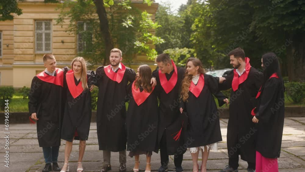 Students celebrate graduation. Young people dressed in gowns and ...