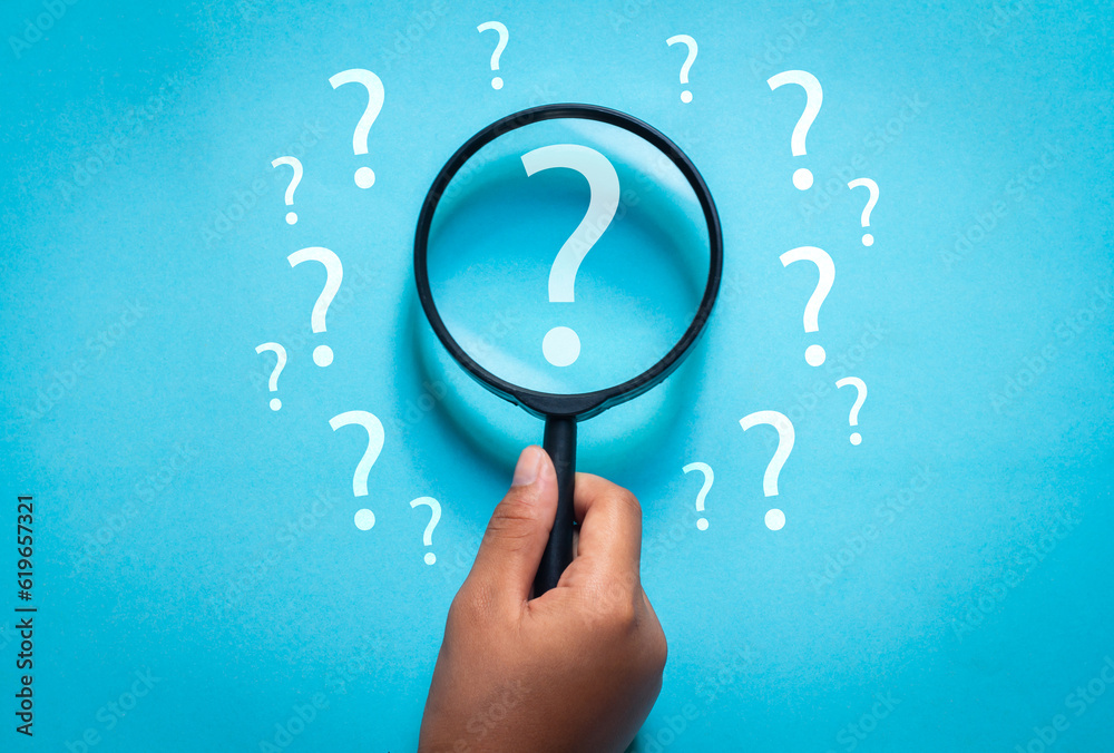 magnifying glass on blue background. hand holding a magnifying glass ...