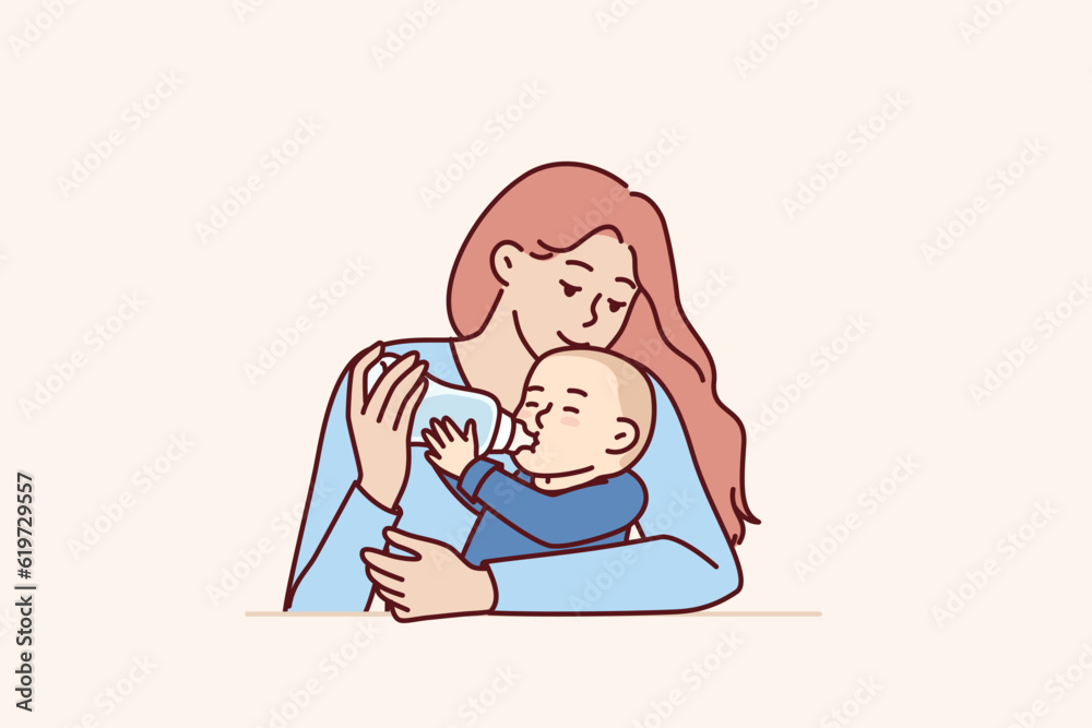 Woman kisses baby while feeding artificial milk from bottle to ...