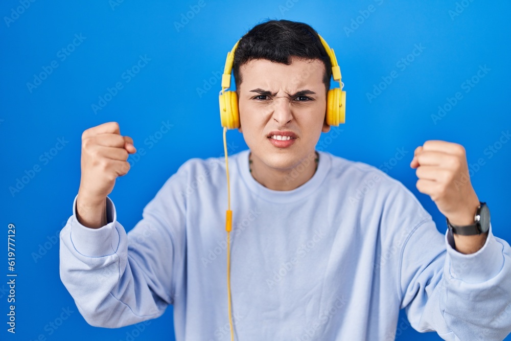 Non binary person listening to music using headphones angry and mad ...
