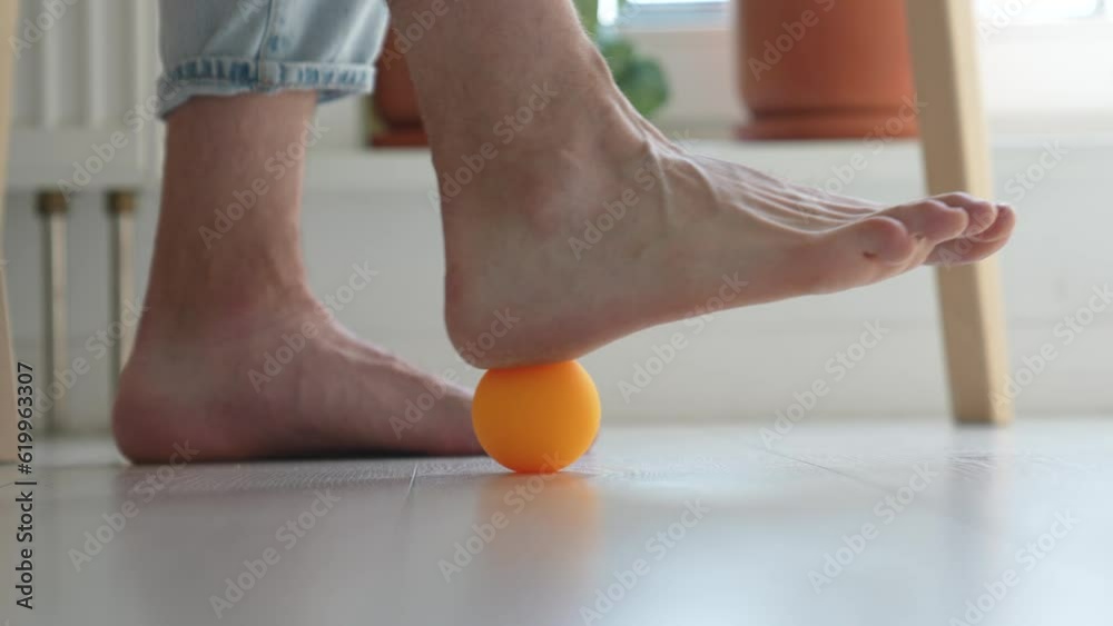 Man using silicone ball for foot massage under table during long ...