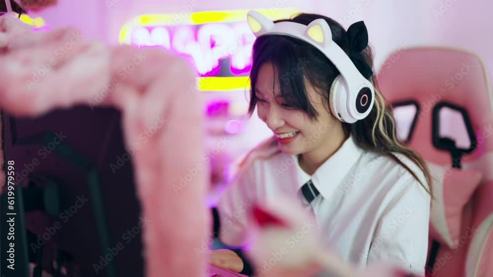 Young Asian woman esport player playing online game on computer in ...